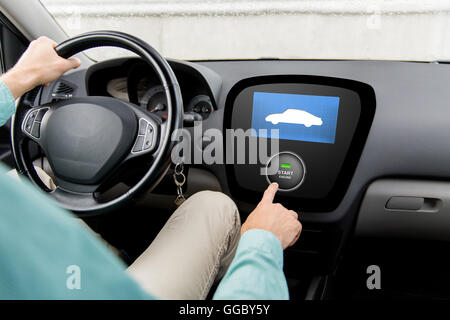 Close up of a man starting a luxury car. Man's hand holding a car key ...