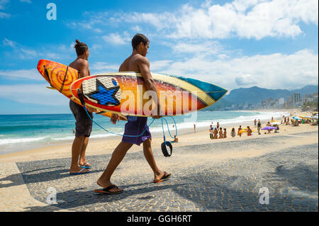 Young Brazilian surfers walking with their surfboards from Arpoador ...