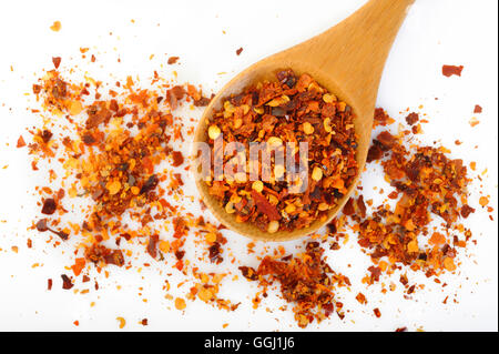 Chilli powder in wooden spoon with dry red chilly on yellow background ...