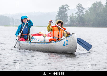 Canoe in rain by lake Stock Photo - Alamy