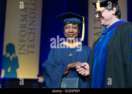 Graduation candidate in cap and gown receives diploma at Western ...