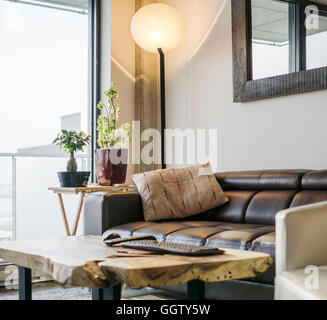 Sofa, table and floor mirror near white wall in interior of room Stock ...