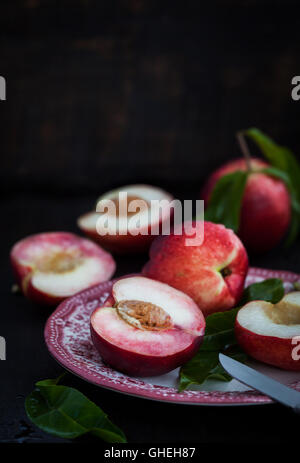 fresh nectarines with leaves on wooden background Stock Photo - Alamy