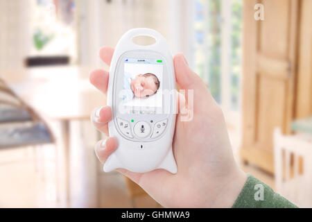 Mother or father checking baby through baby monitor Stock Photo - Alamy