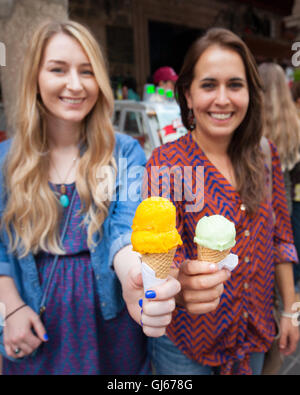 A couple of tourists enjoy an ice cream in Sneem village, a very ...