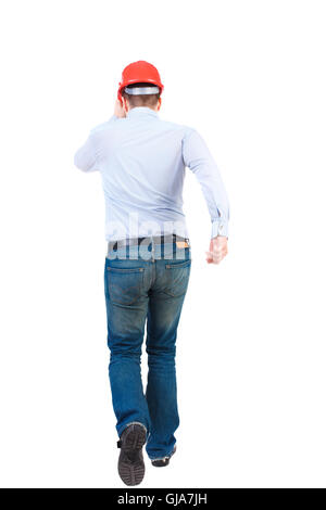 Back view of running engineer in helmet. Walking guy in motion. Rear ...