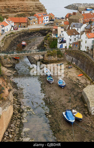 Fishing boats stranded in Staithes Harbour, North Yorkshire, at low ...