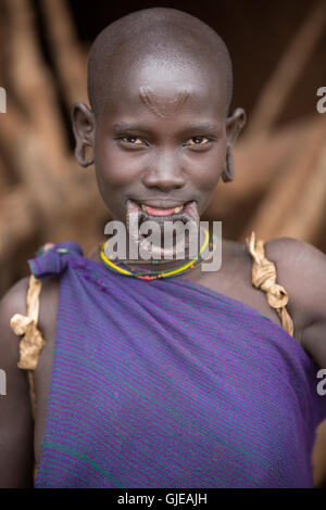 Portrait of young Suri / Surma woman with ritual scarification on chest ...