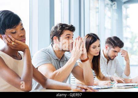 Team of business men and women tired rubbing nose and eyes feeling ...