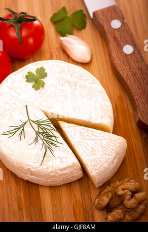 Yellow round dairy soft cheese piece Stock Photo - Alamy