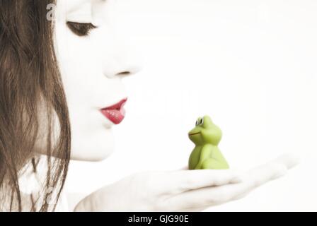 Face, kiss and profile of woman with frog in studio on blue background ...