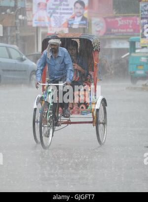 Allahabad, India. 16th Aug, 2016. Commuters use plastic sheet to be ...