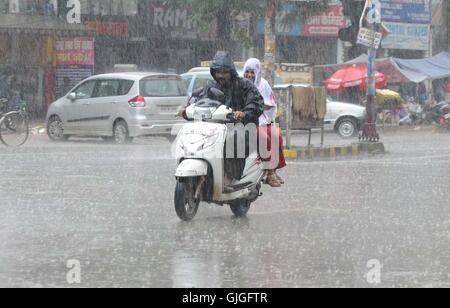 Allahabad, India. 16th Aug, 2016. Commuters use plastic sheet to be ...