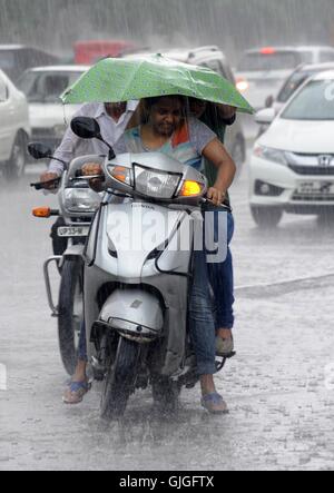 Allahabad, India. 16th Aug, 2016. Commuters use plastic sheet to be ...