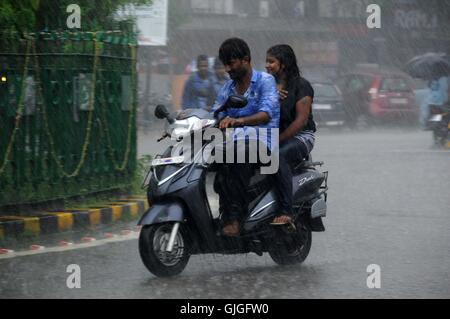 Allahabad, India. 16th Aug, 2016. A girl ride scooter during heavy rain ...