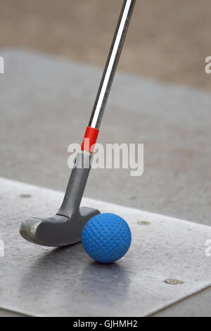 Miniature golf putter by blue ball and hole Stock Photo - Alamy