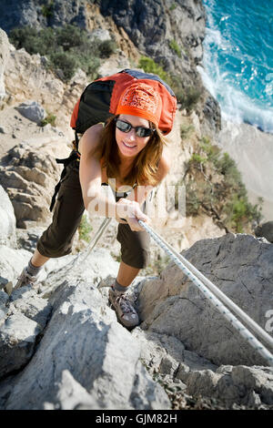 A climber smiles and laughs while climbing a rock route in Joshua Tree ...