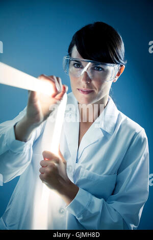 Italian woman holding neon stick in lab Stock Photo - Alamy