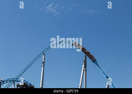 blue roller coaster loop with cart in front of blue sky Stock Photo - Alamy