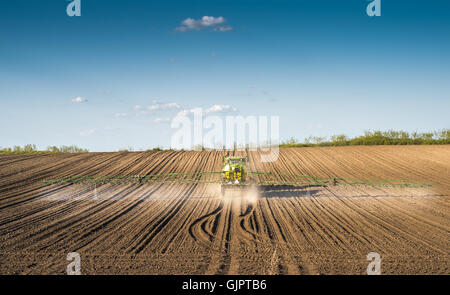 Tractor spraying pesticides at wheat fields Stock Photo - Alamy