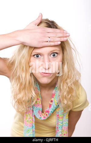 Anxious and embarrassed blond young woman with blue eyes, frowning and ...