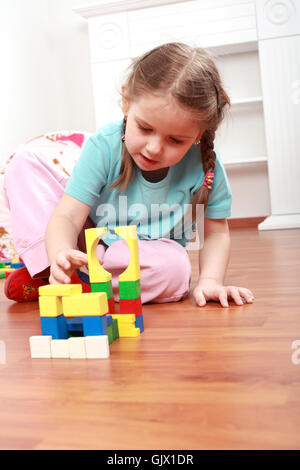 Adorable toddler playing with construction blocks sitting on table at ...