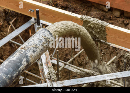 Concrete pumping hose filling foundation hole Stock Photo - Alamy