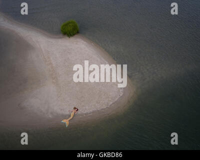 Young mermaid laying in the sand at the bottom of the sea Stock Photo ...