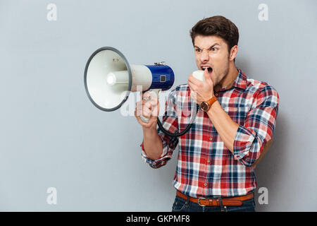 Young person shouting in loudspeaker Stock Photo - Alamy