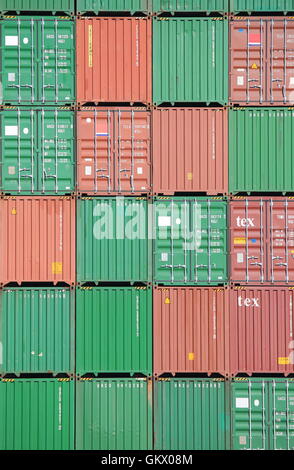 Containers piled up in a cargo yard against a blue sky. transport ...