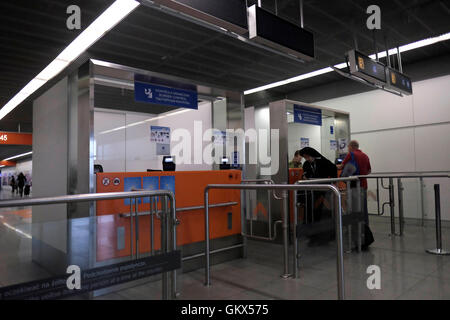 Passengers go through passport control booth in Schiphol airport in ...