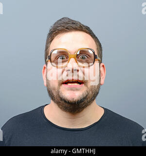 Portrait of a confused chubby geek against gray background Stock Photo ...