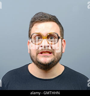 Portrait of a confused chubby geek against gray background Stock Photo ...