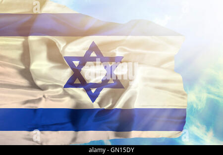 Israel waving flag against blue sky with sunrays Stock Photo - Alamy