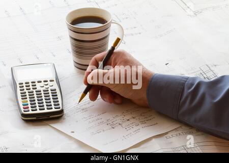 Engineer doing hand calculations on a calculation sheet, with a ...