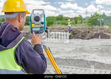 Surveyor engineer is measuring level on construction site. Surveyors ...
