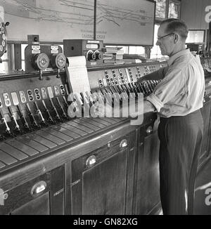1950s, historical, male railway signal operator sitting at the control ...