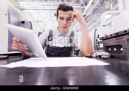 Man working with documents at plant near CNC machines Stock Photo - Alamy