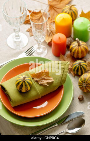 Autumn table setting with plate, pumpkin and candles Stock Photo - Alamy