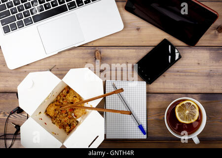 Eating at work place near laptop Stock Photo - Alamy