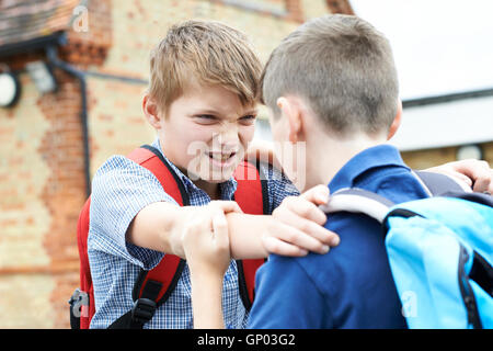 Two boys arguing in the schoolyard, a girl watching Stock Photo - Alamy