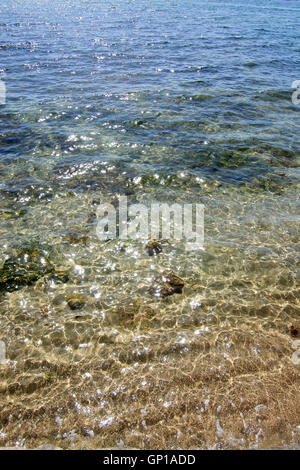 Green shallow water with sandy bottom and sun glitter in Mallorca ...