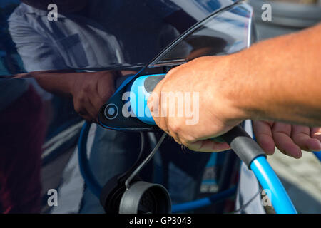 human hand with charger charging eco green alternative electric vehicle ...