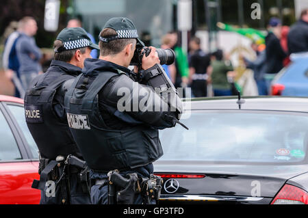 Two armed PSNI police officers stand on the street in uniform, Belfast ...