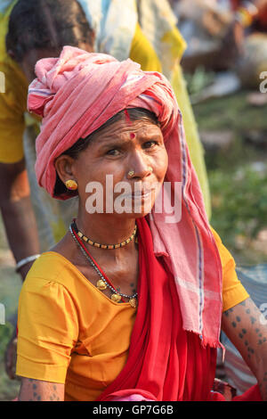 Woman at weekly tribal market wearing brightly coloured clothing and ...