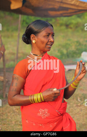 Woman at weekly tribal market wearing brightly coloured clothing and ...