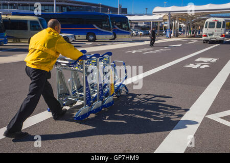 Man pushing luggage trolleys, narita international airport, tokyo ...
