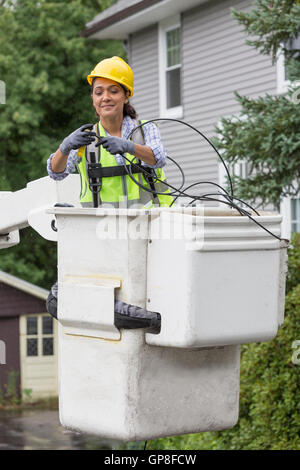 Hispanic female cable lineman stripping cable in the rain Stock Photo ...