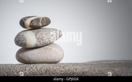 stacked rounded stone pebble arrangement in white back Stock Photo - Alamy