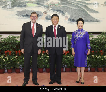 China's President Xi Jinping and his wife Peng Liyuan wave to the crowd ...